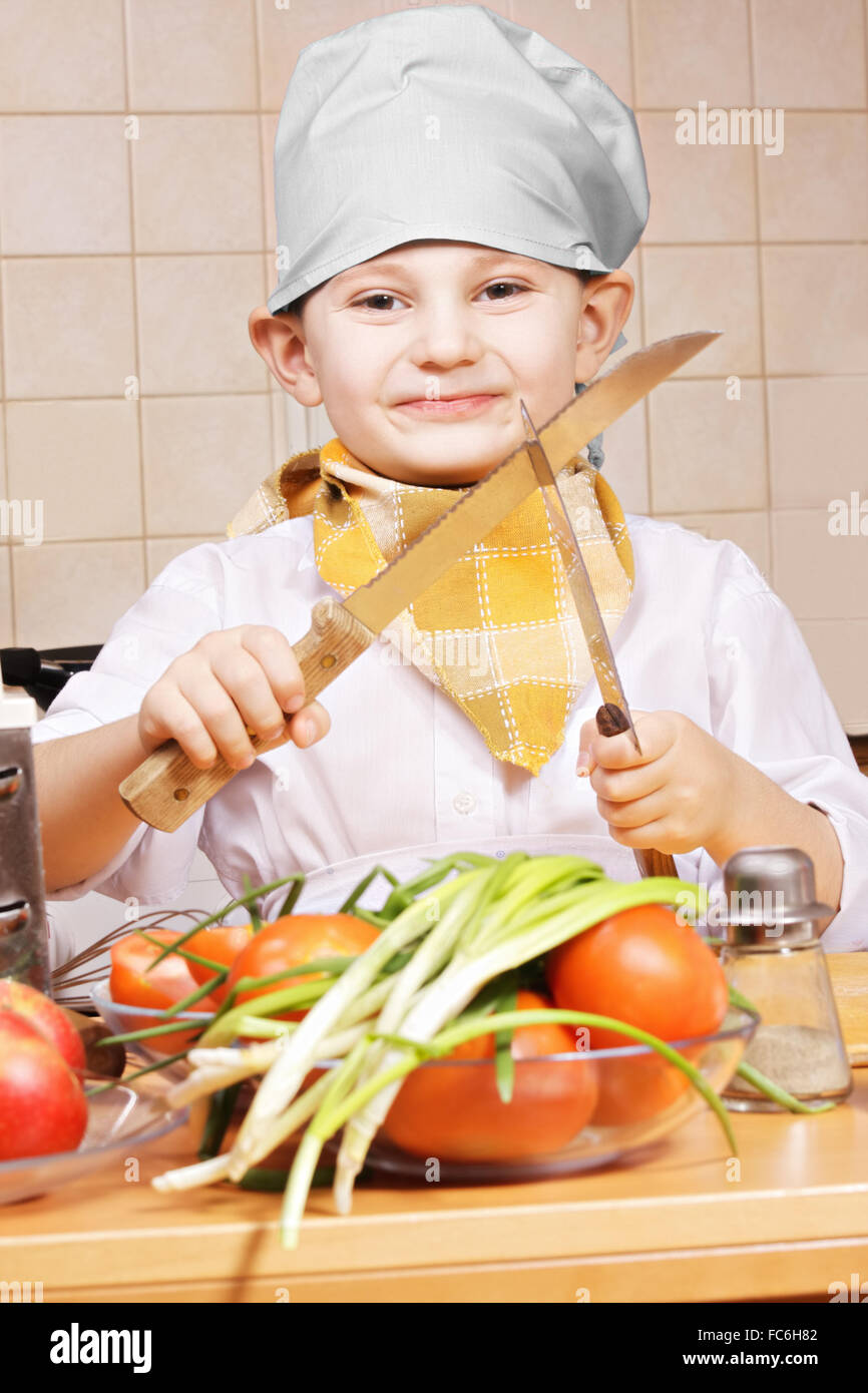Positive little cook with two knives Stock Photo - Alamy