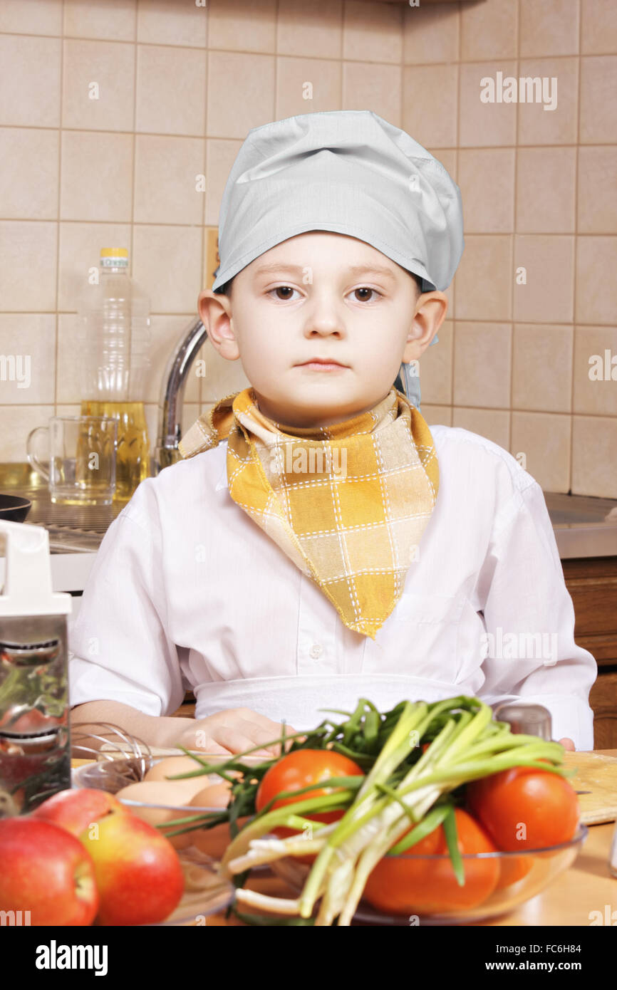 Serious little cook with tomatoes an apples Stock Photo - Alamy
