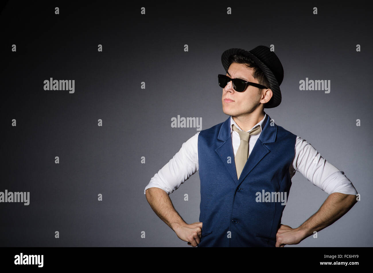Young man in blue vest and hat against gray Stock Photo - Alamy
