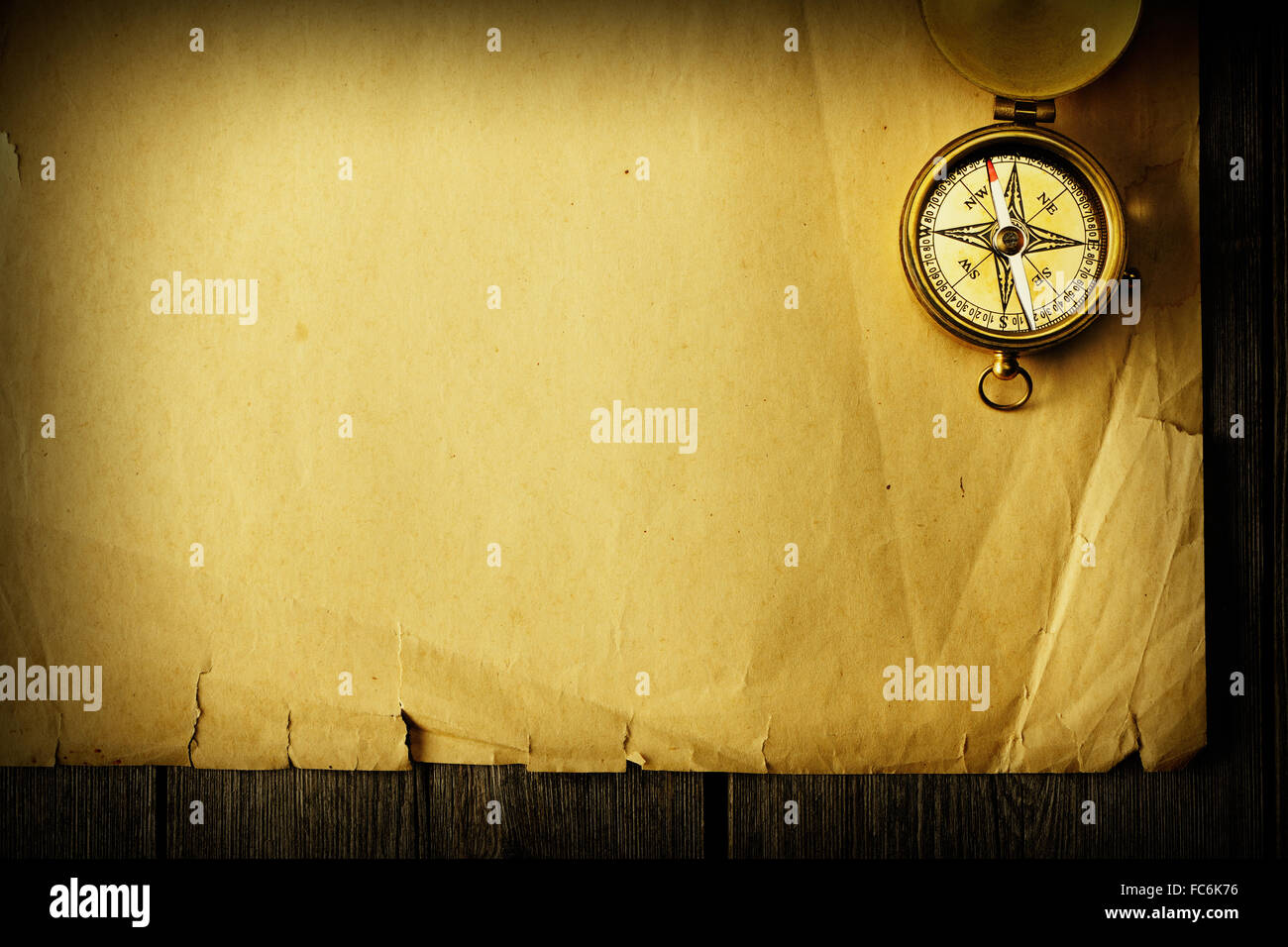 Antique brass compass over old background Stock Photo - Alamy