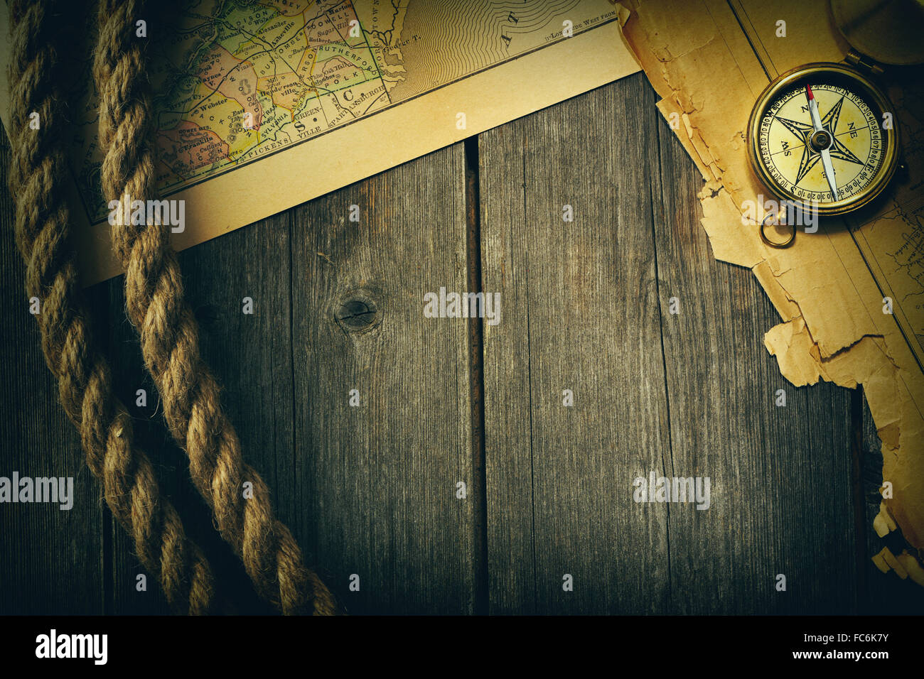 Antique compass and rope over old map Stock Photo - Alamy