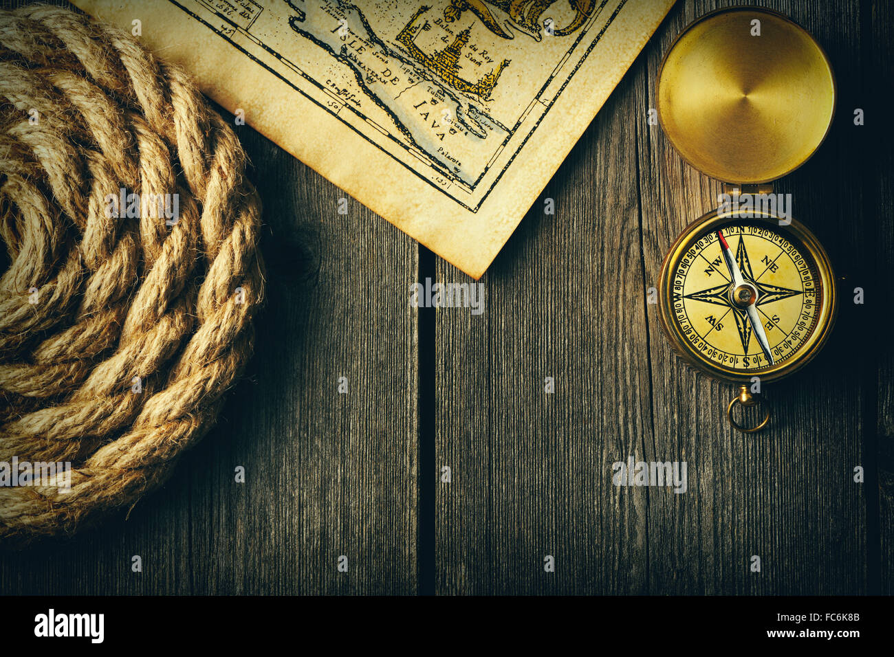 Antique compass and rope over old map Stock Photo - Alamy