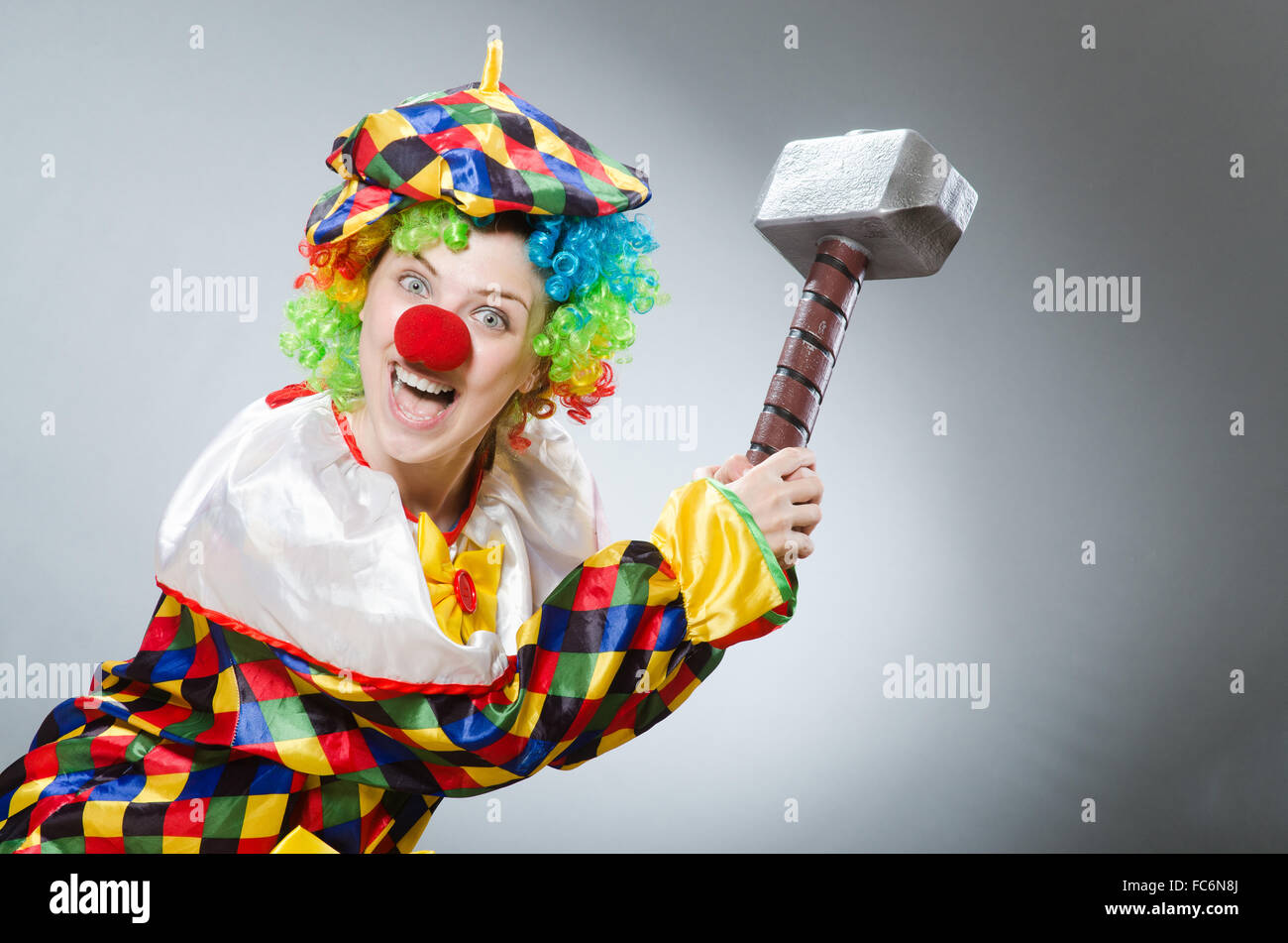 Clown with hammer in funny concept Stock Photo - Alamy