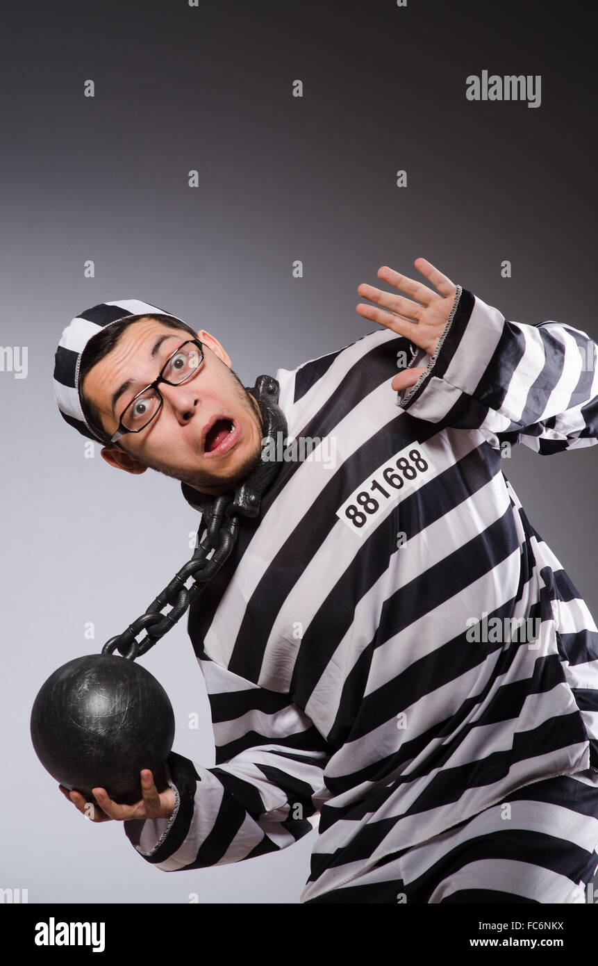 Young prisoner in chains against gray Stock Photo - Alamy