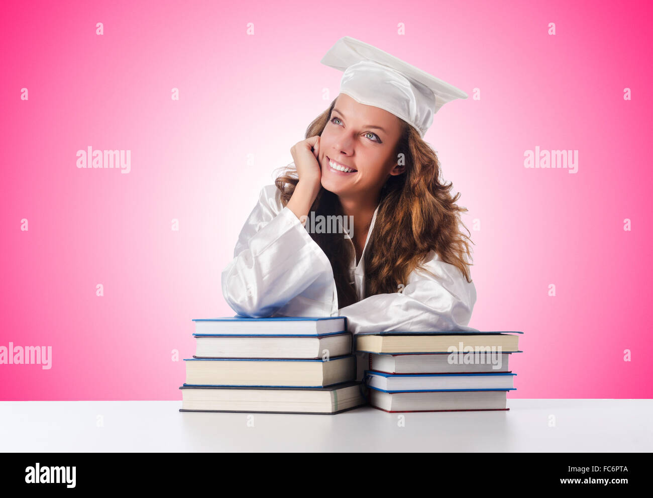 Happy graduate with lots of books on white Stock Photo - Alamy