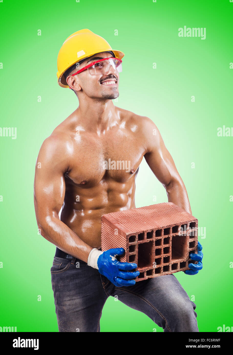 Muscular builder with bricks on white Stock Photo - Alamy