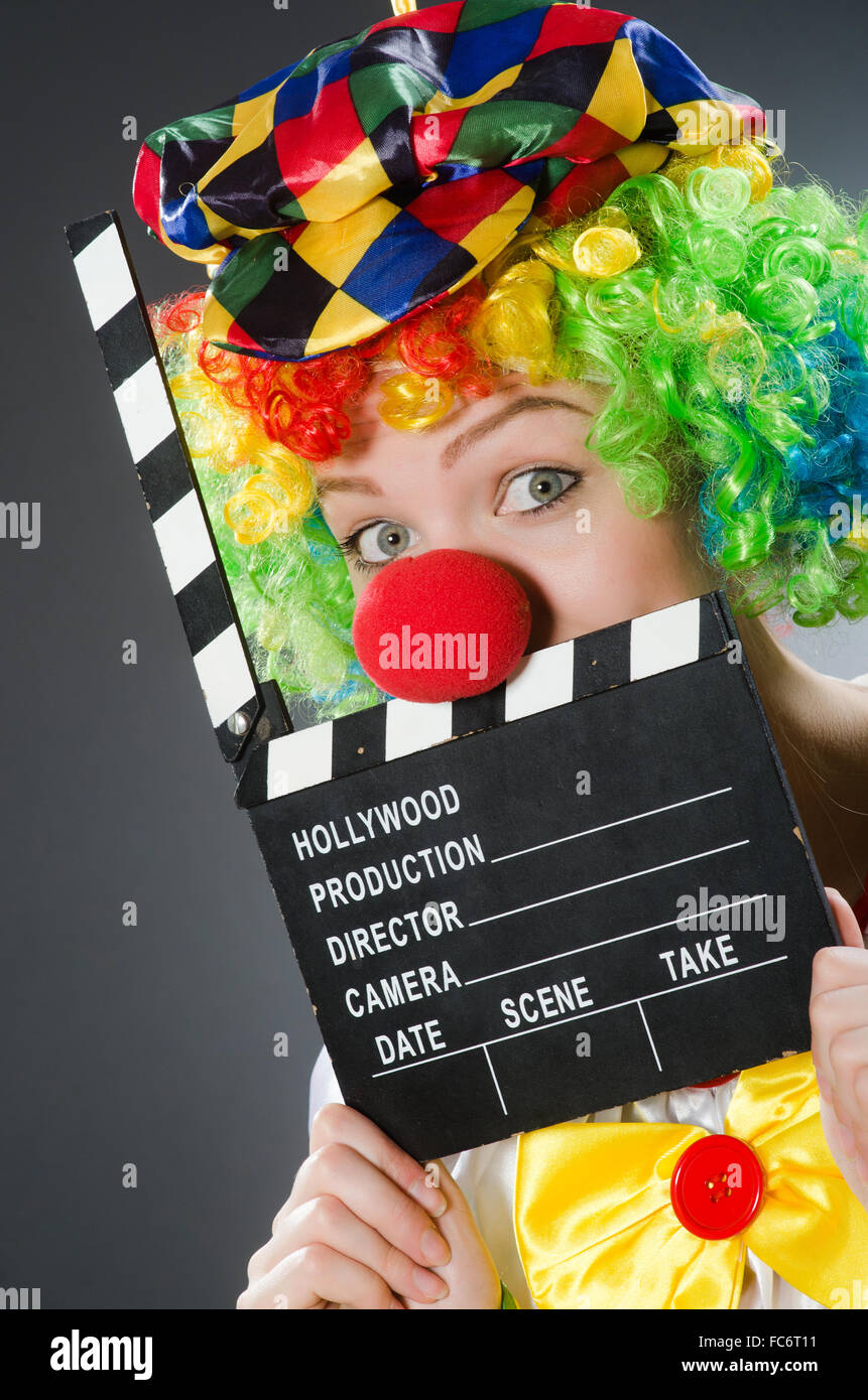 Clown with movie clapper in funny concept Stock Photo - Alamy