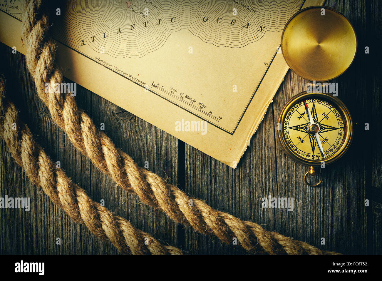 Antique compass and rope over old map Stock Photo - Alamy