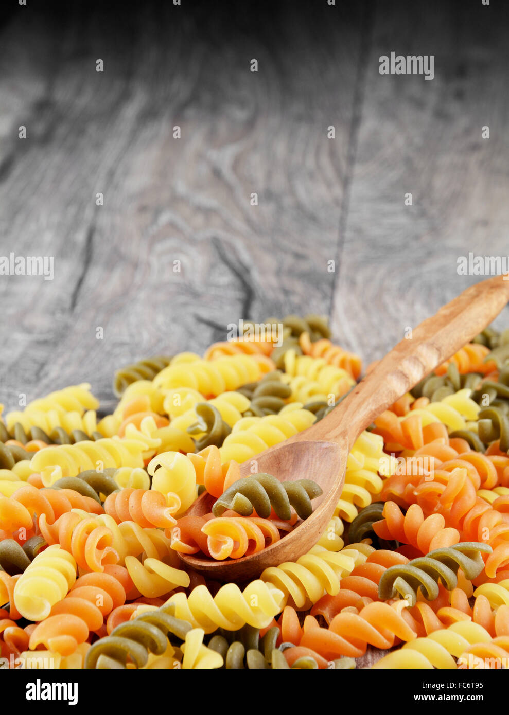 Raw eliche tricolori pasta background Stock Photo - Alamy