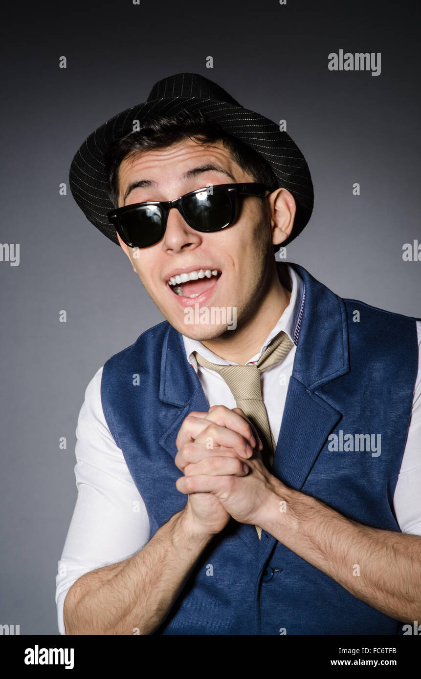 Young man in blue vest and hat against gray Stock Photo - Alamy