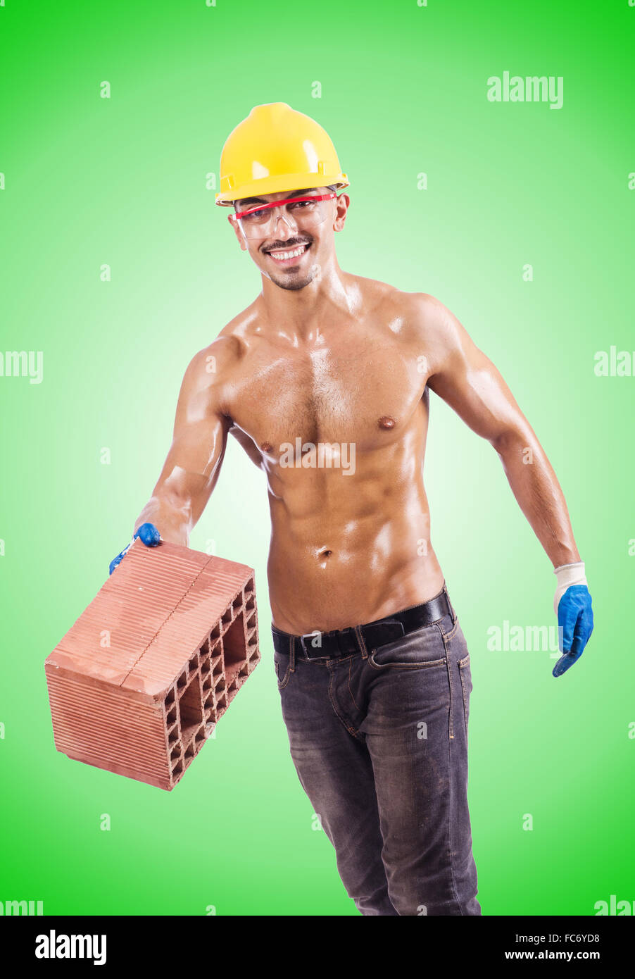 Muscular builder with bricks on white Stock Photo - Alamy