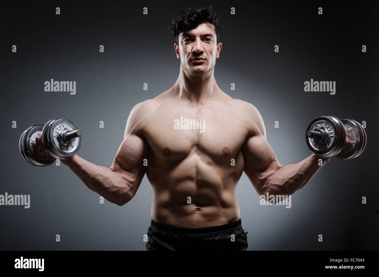 Muscular ripped bodybuilder with dumbbells Stock Photo - Alamy
