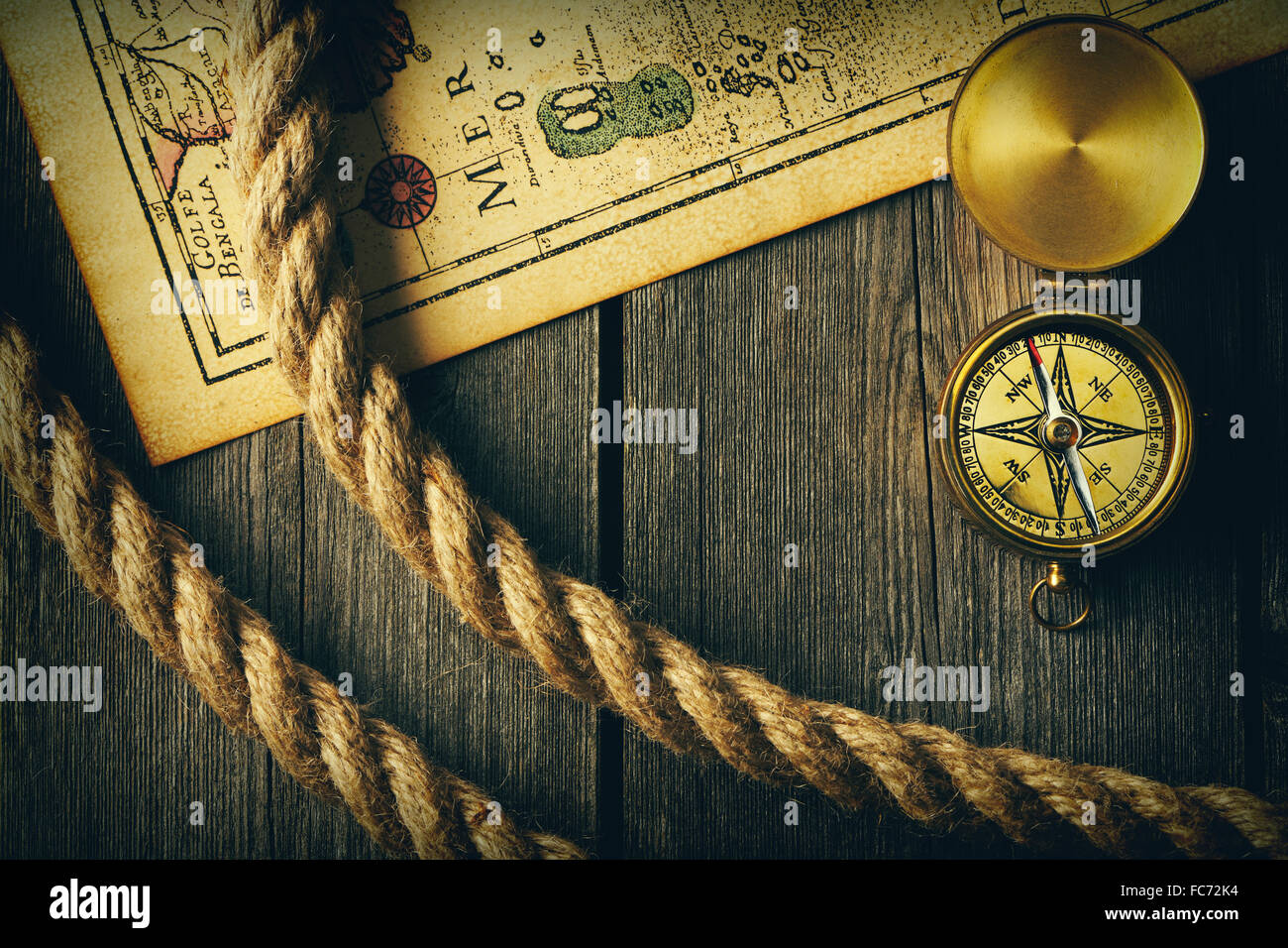 Antique compass and rope over old map Stock Photo - Alamy