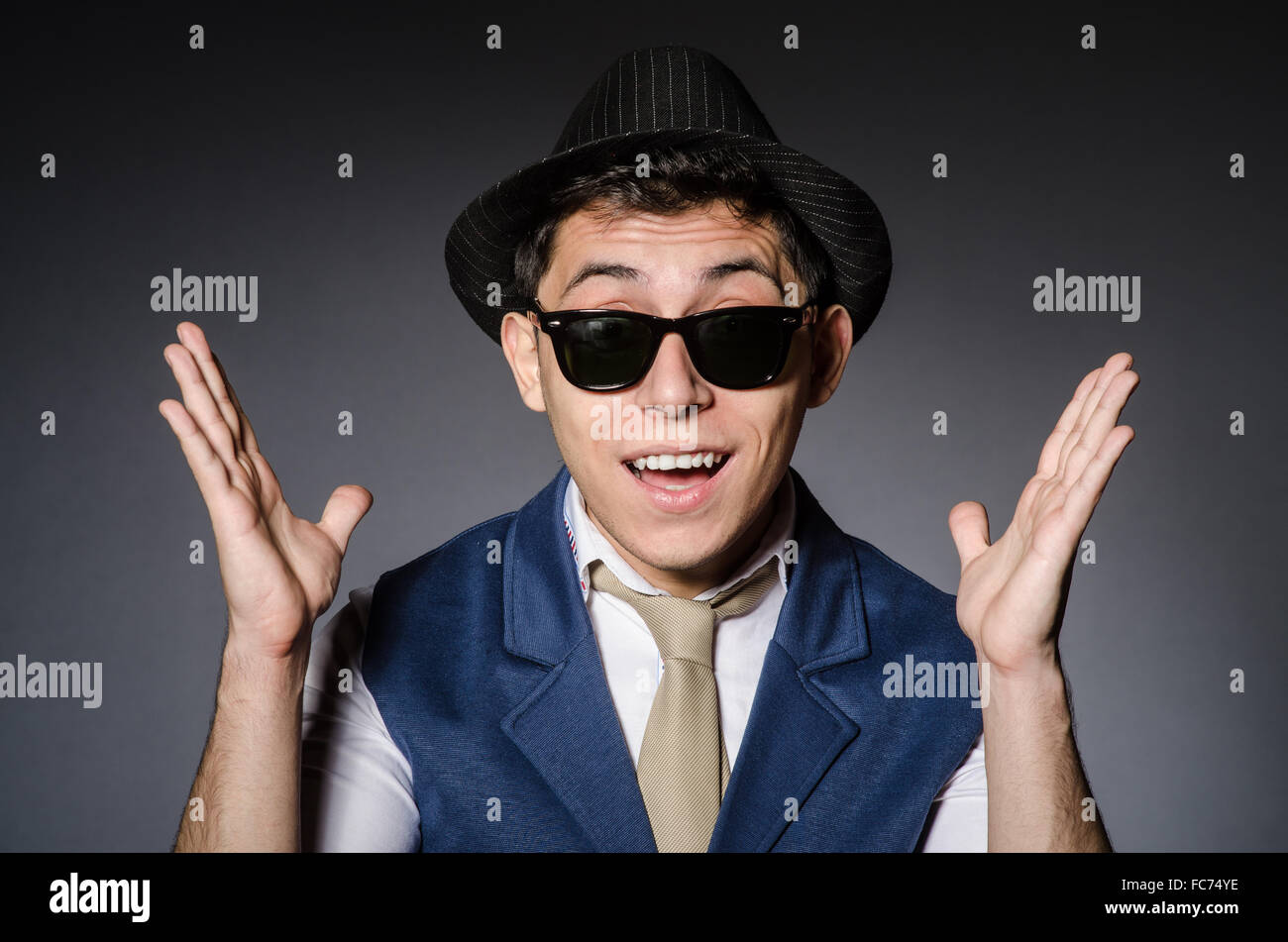 Young man in blue vest and hat against gray Stock Photo - Alamy