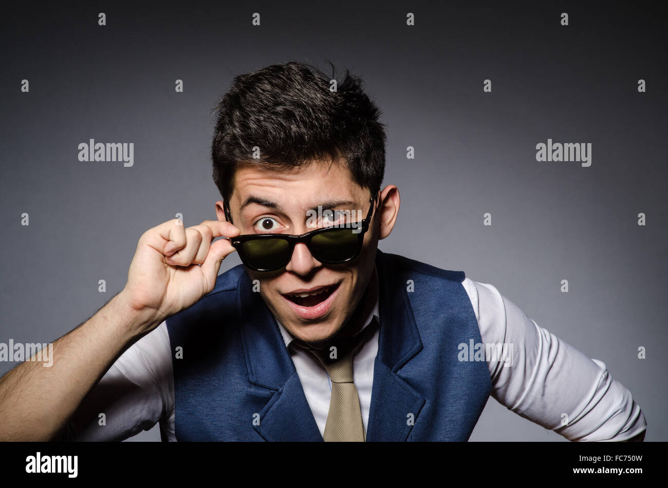 Young man in blue vest against gray Stock Photo - Alamy