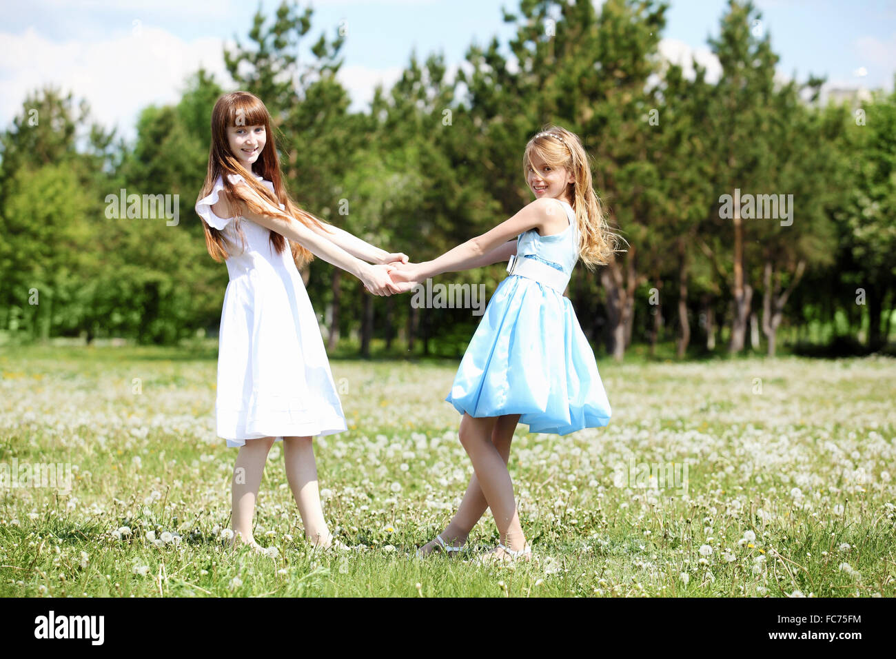 two girls spending time together in the summer park Stock Photo - Alamy