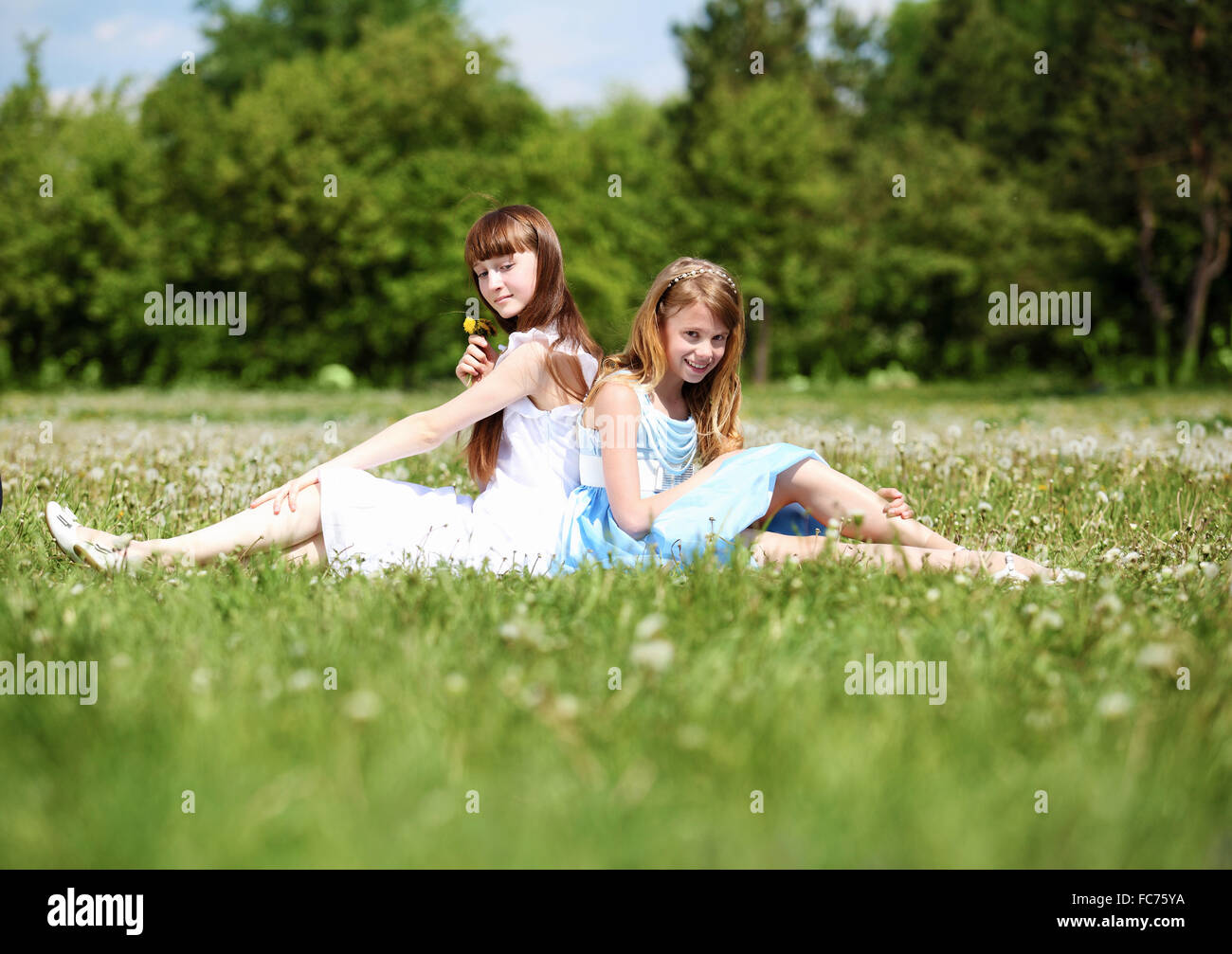two girls spending time together in the summer park Stock Photo - Alamy