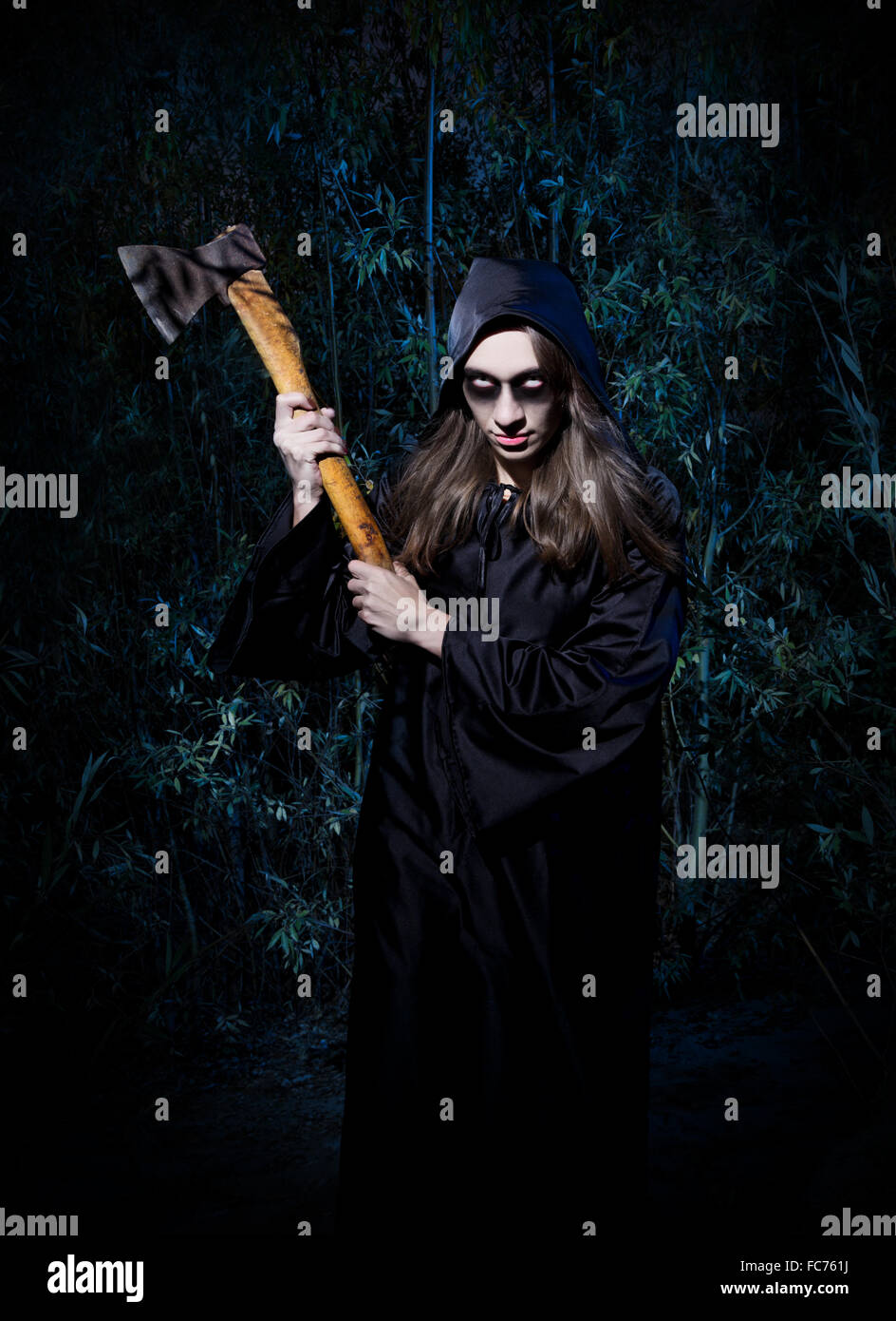 Woman with axe in forest Stock Photo - Alamy