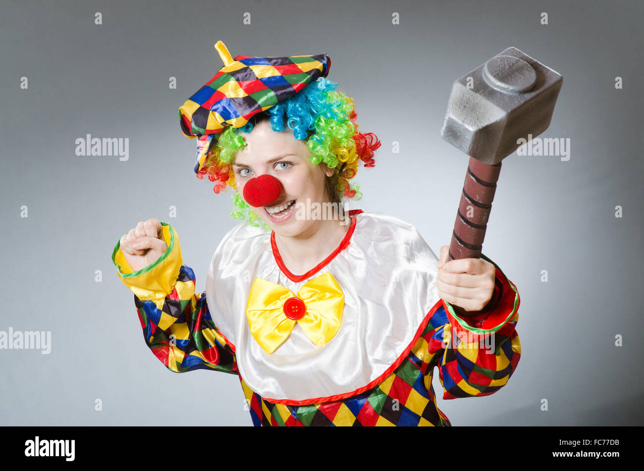 Clown with hammer in funny concept Stock Photo - Alamy