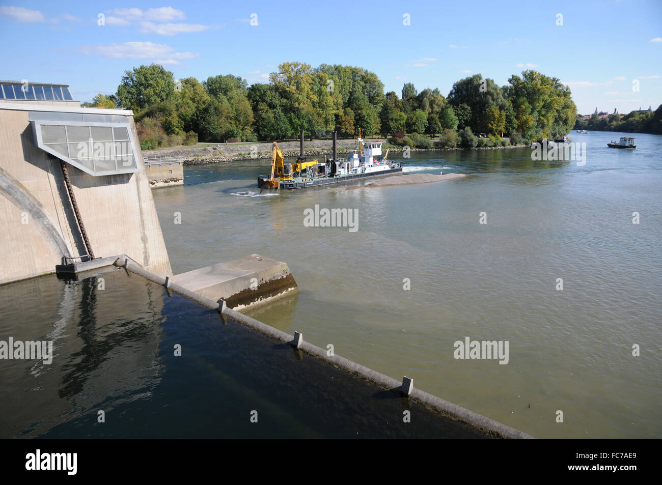 Excavator on a ship digging pebbles Stock Photo - Alamy