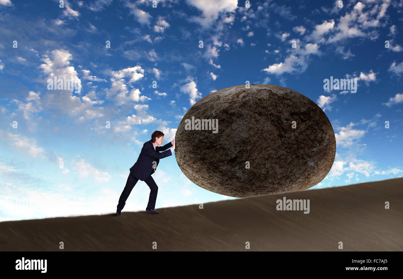 Image of businessman rolling a giant stone Stock Photo - Alamy