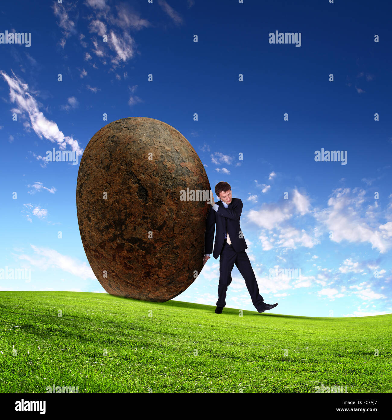 Image of businessman rolling a giant stone Stock Photo - Alamy