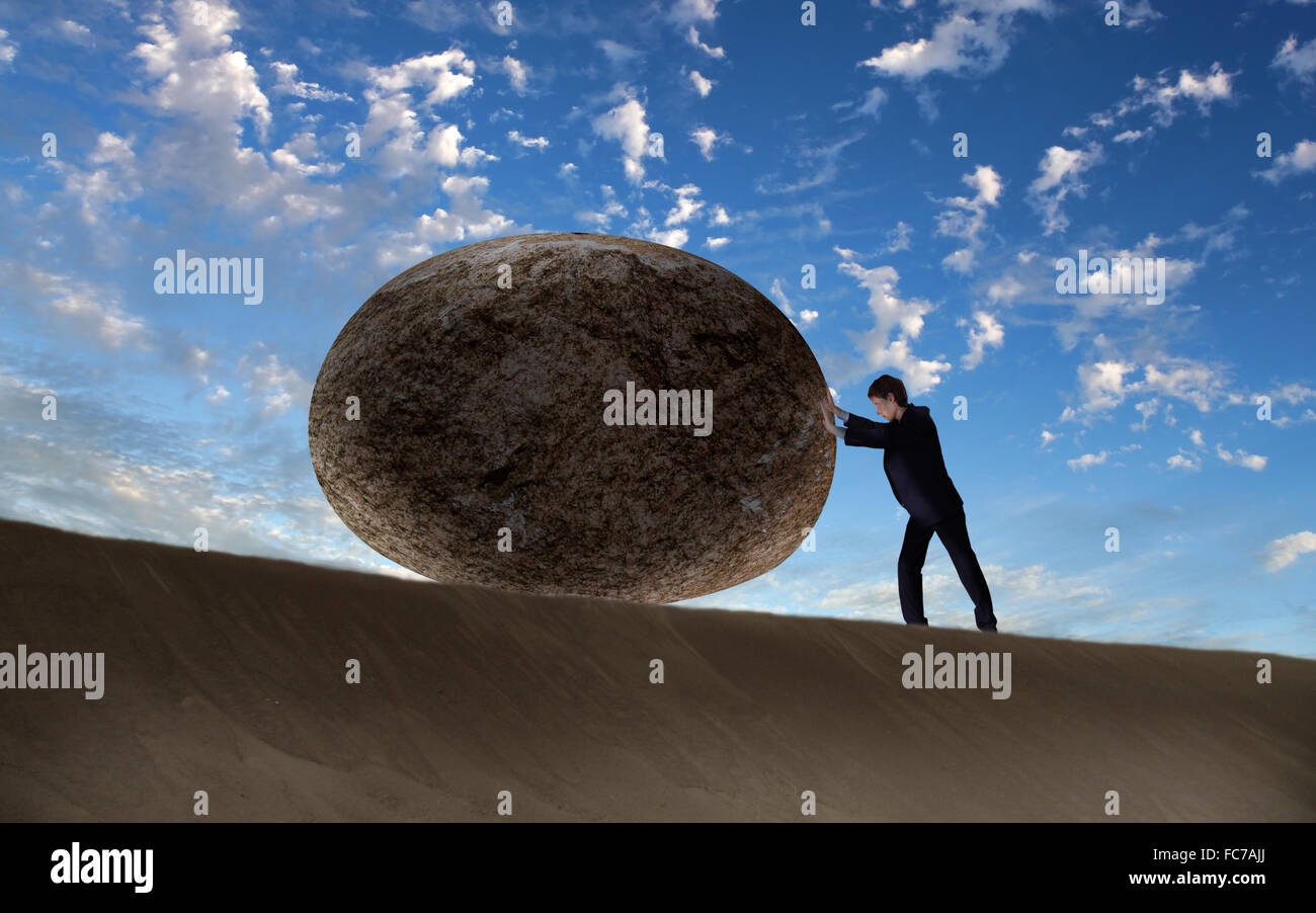 Image of businessman rolling a giant stone Stock Photo - Alamy