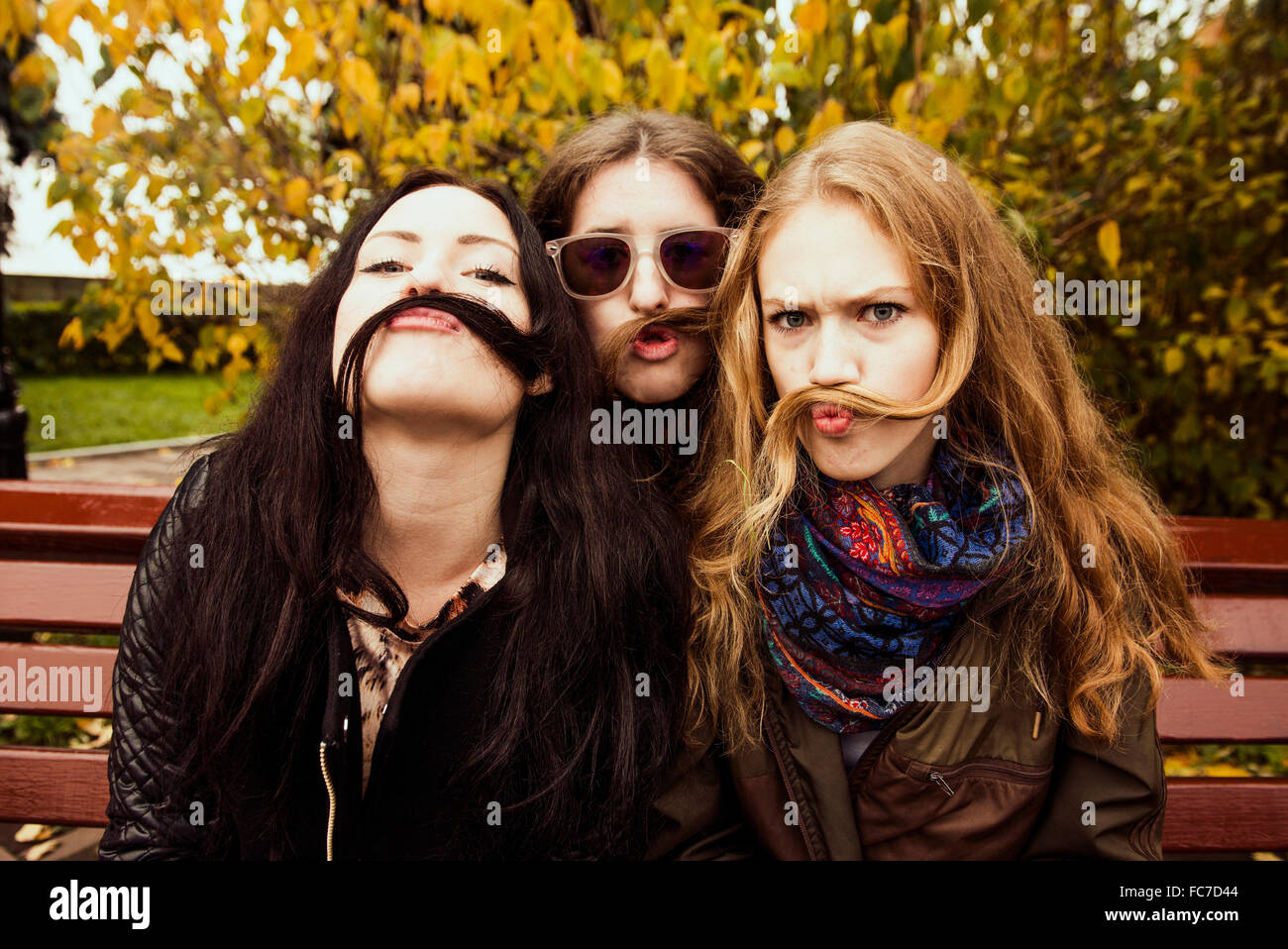 Caucasian women posing on bench Stock Photo - Alamy