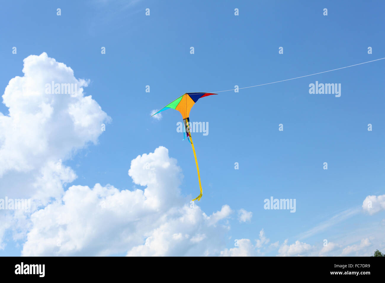 wind kite flying in the blue summer sky Stock Photo - Alamy