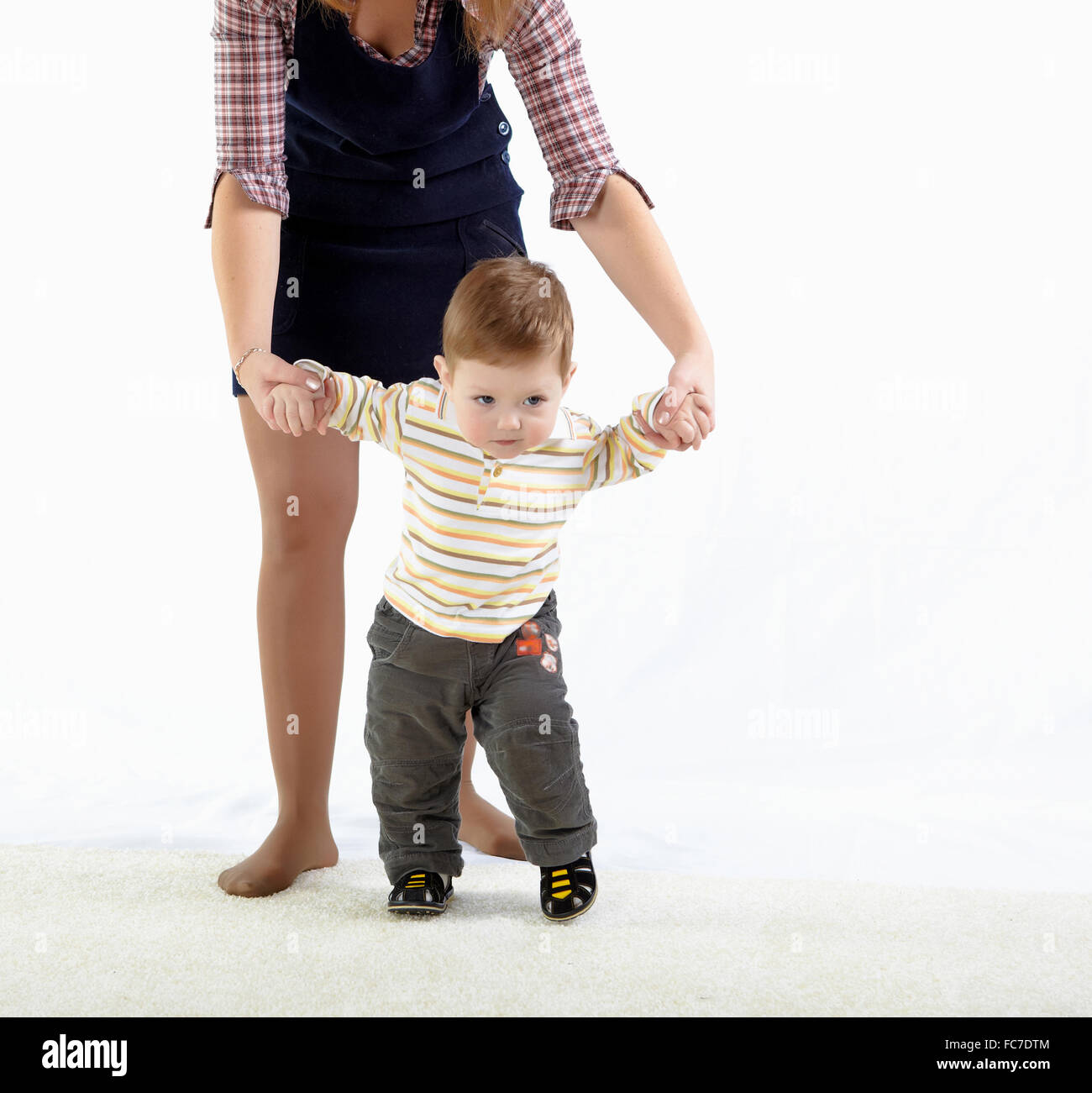 little baby learning how to walk with a parent Stock Photo - Alamy