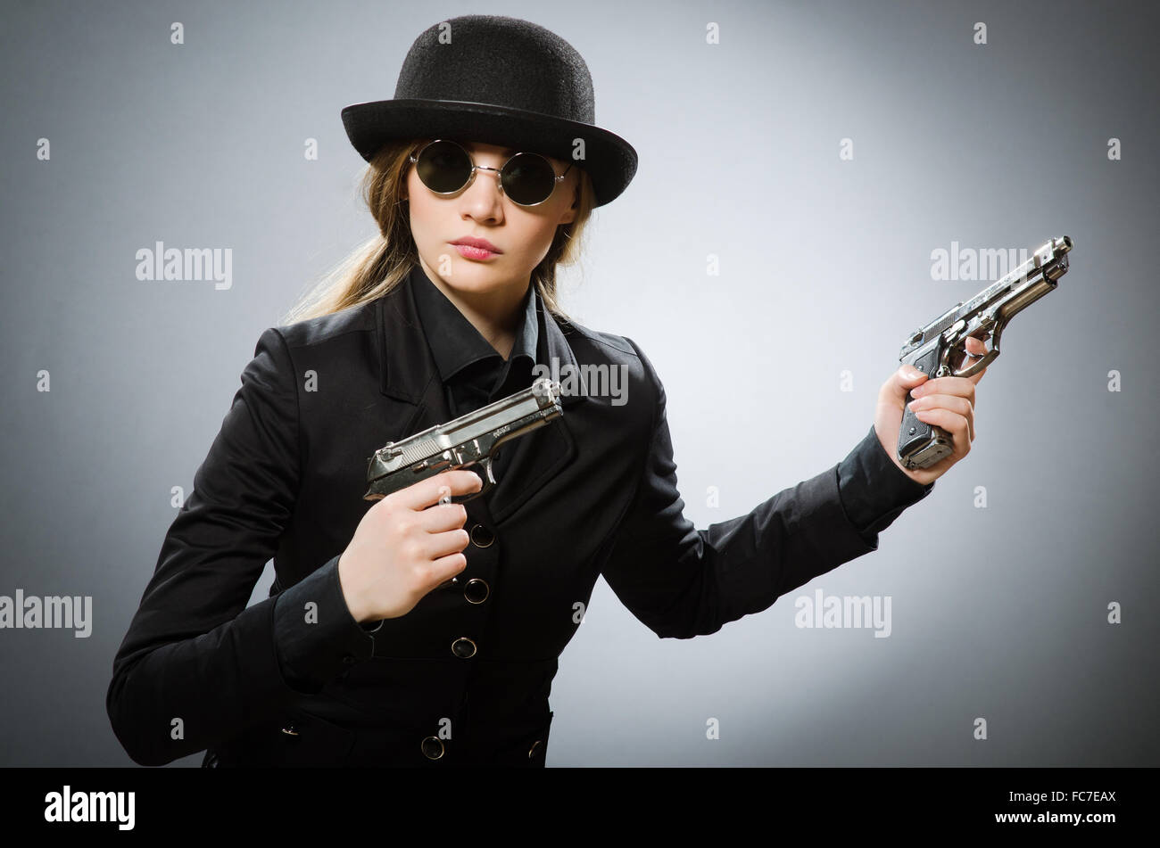 Female spy with weapon against gray Stock Photo - Alamy Female spy with weapon against gray Stock Photo - Alamy