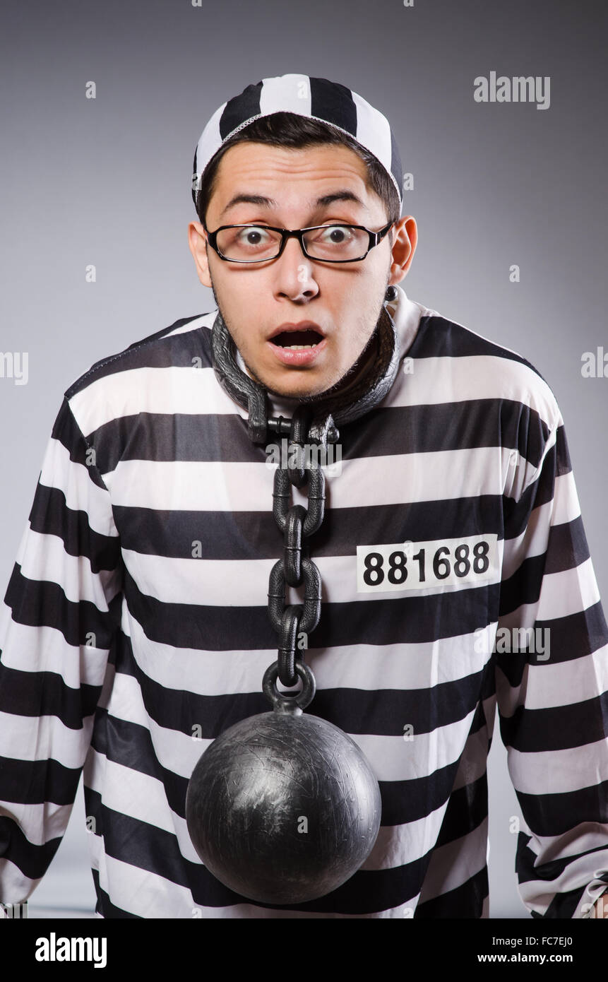Young prisoner in chains against gray Stock Photo - Alamy