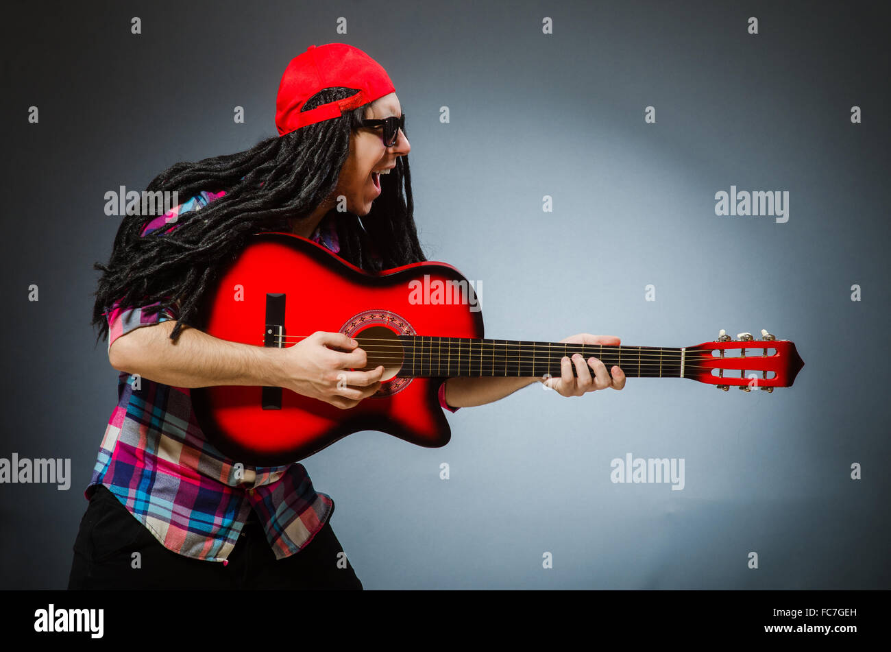 Funny man playing guitar in musical concept Stock Photo - Alamy