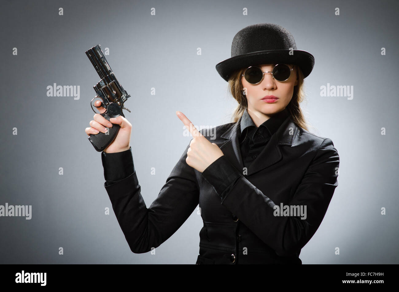 Female spy with weapon against gray Stock Photo - Alamy Female spy with weapon against gray Stock Photo - Alamy