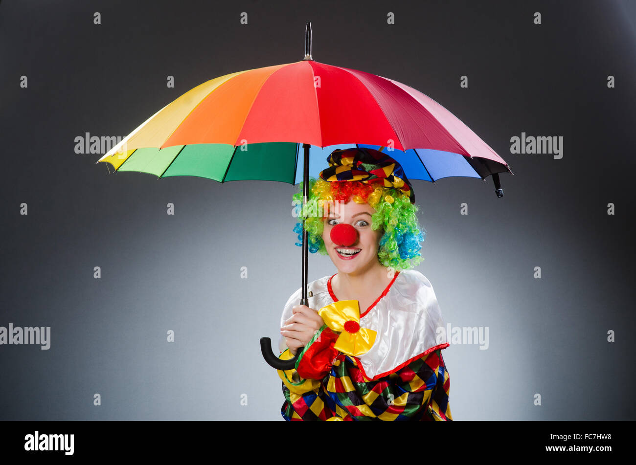 Clown with umbrella in funny concept Stock Photo - Alamy