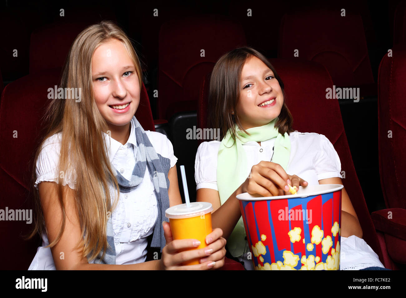 Two young girls watching movie in cinema Stock Photo - Alamy