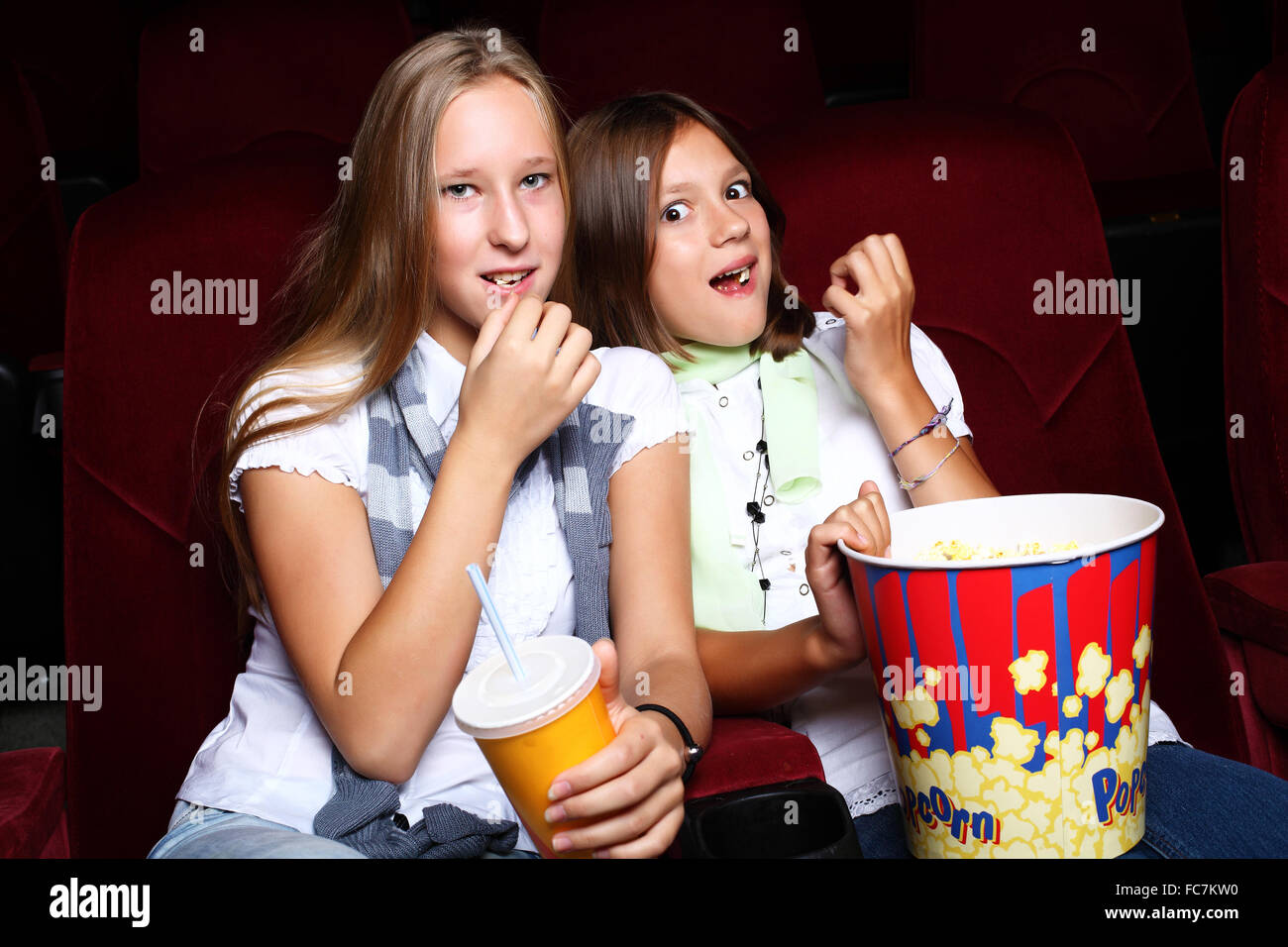 Two young girls watching movie in cinema Stock Photo - Alamy
