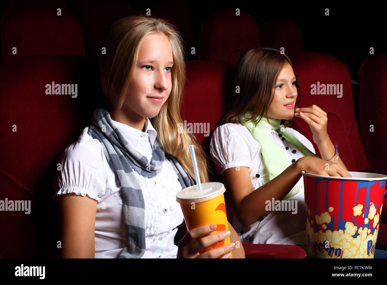 Two young girls watching movie in cinema Stock Photo - Alamy