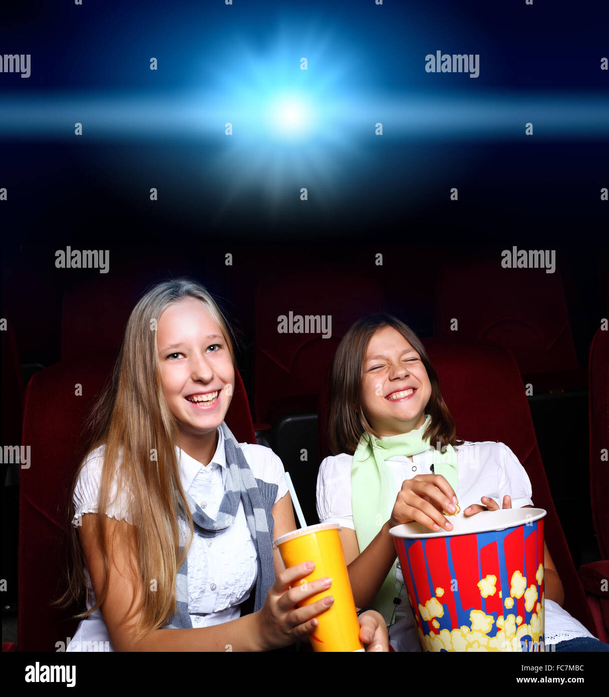 Two young girls watching movie in cinema Stock Photo - Alamy