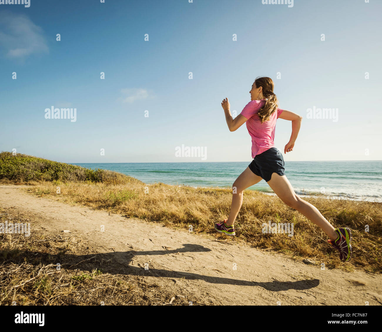Caucasian woman jogging on beach Stock Photo - Alamy