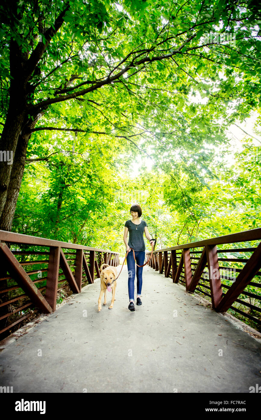 Caucasian woman walking dog on bridge Stock Photo - Alamy