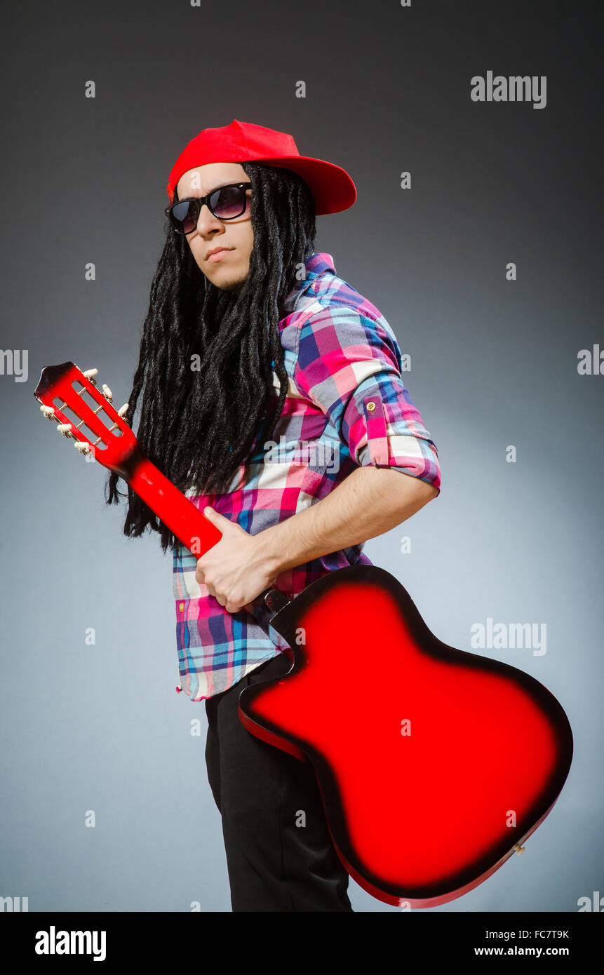 Funny man playing guitar in musical concept Stock Photo - Alamy