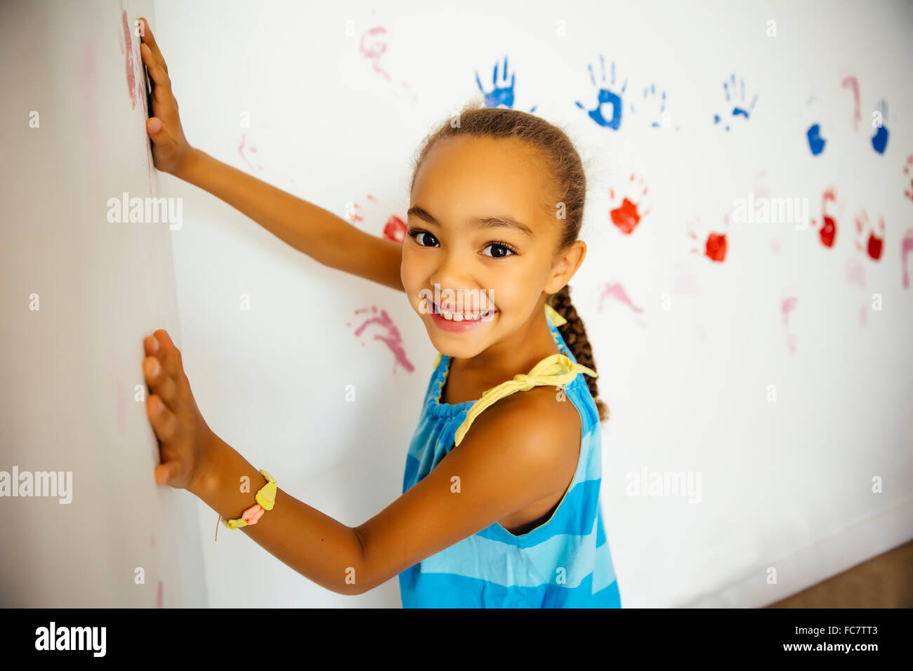 Mixed race girl making hand prints on wall Stock Photo - Alamy