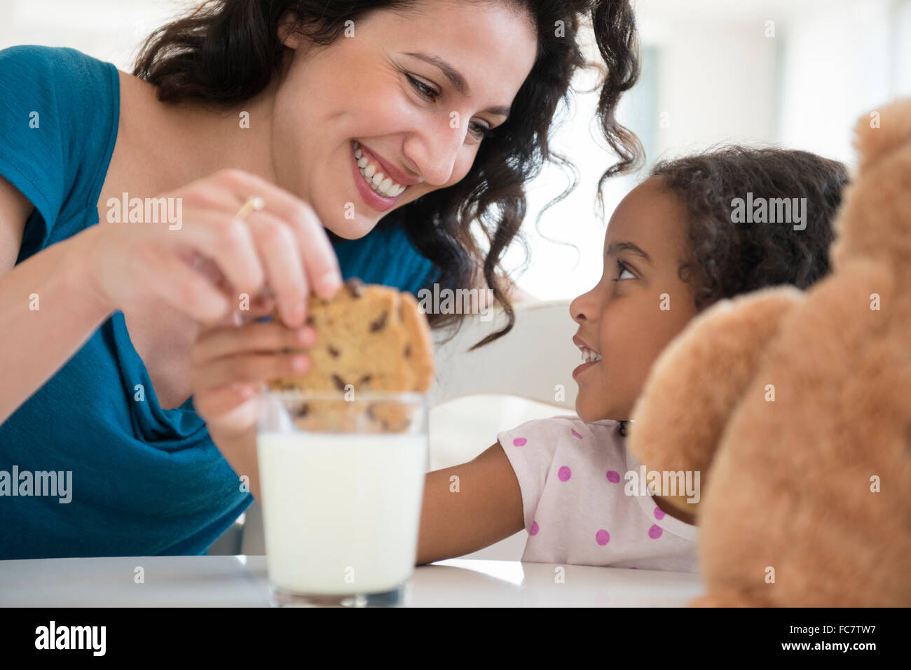 Mother and daughter eating milk and cookies Stock Photo - Alamy