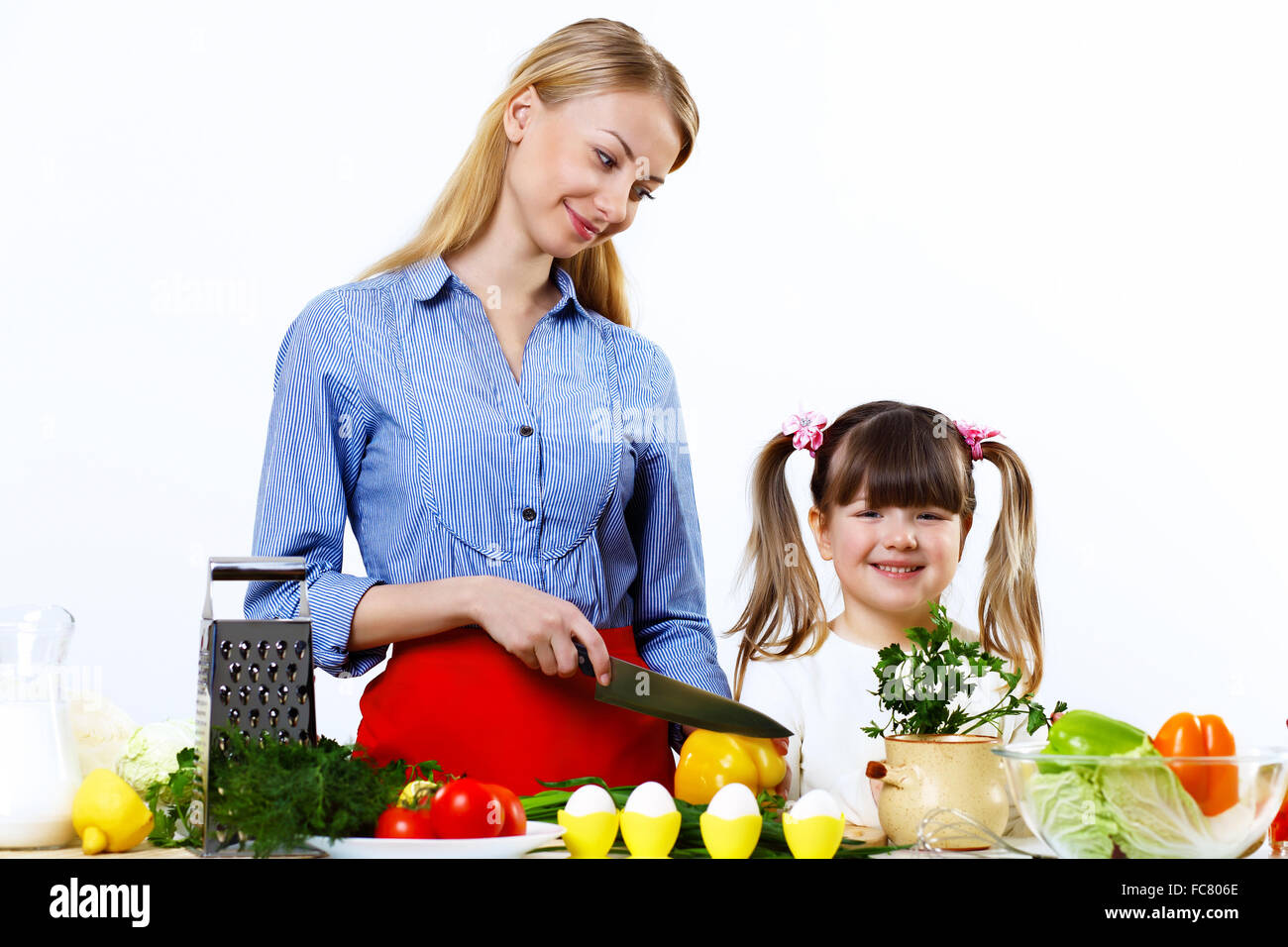 Young mother cooking fresh meal at home with her daoghter Stock Photo ...