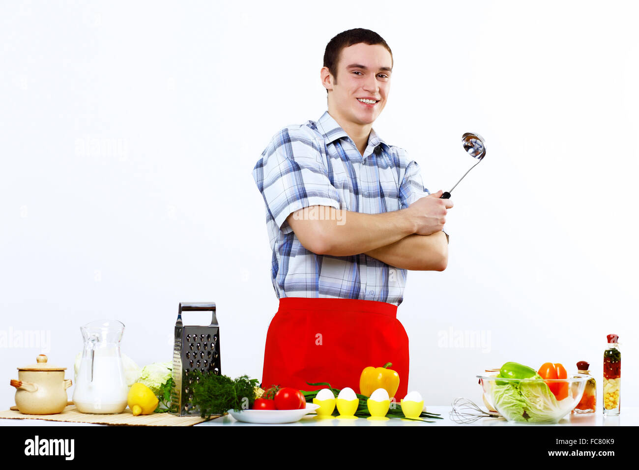 Young husband wearing apron at home cooking meal Stock Photo - Alamy