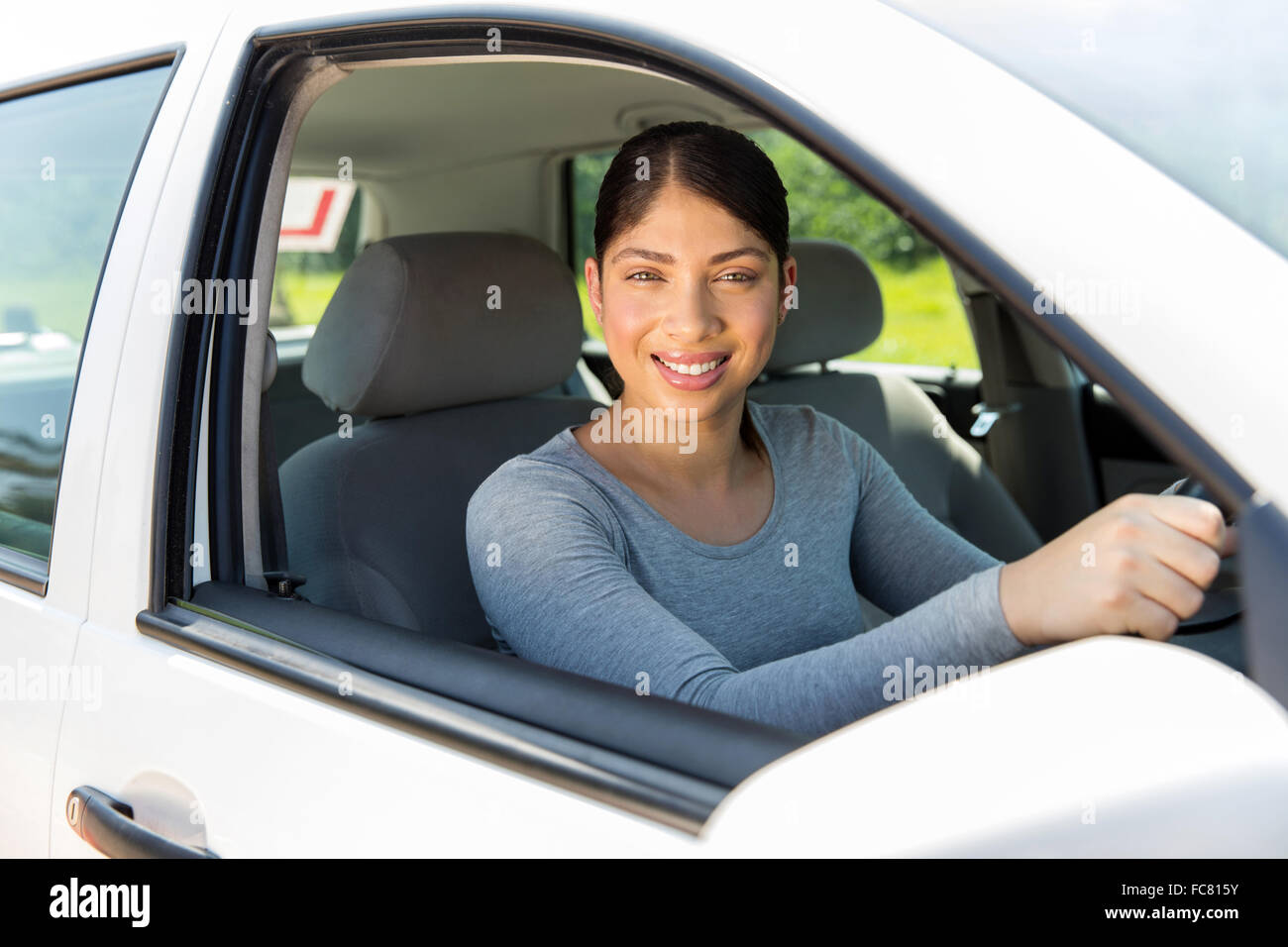 pretty female learner driver looking out of the car window Stock Photo ...