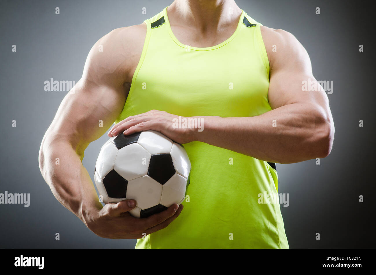 Muscular man with football ball Stock Photo - Alamy
