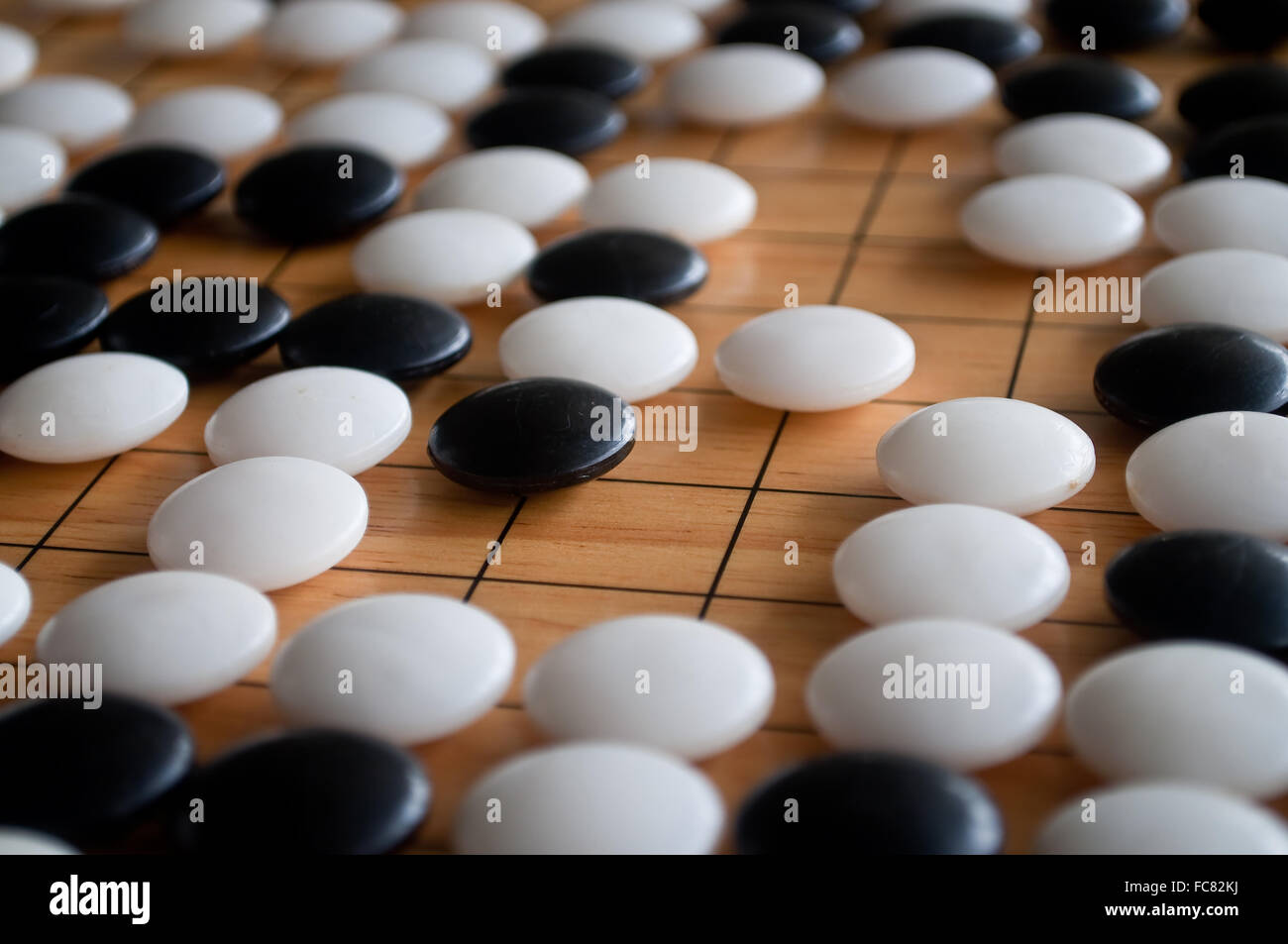 Japanese style Go pieces, curve on both sides, on wooden board showing ...