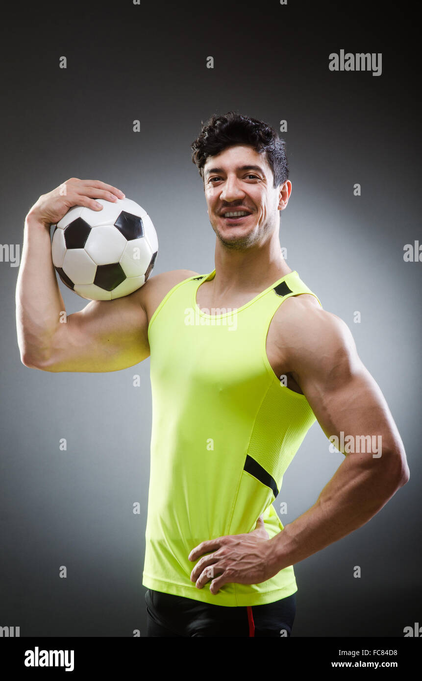 Muscular man with football ball Stock Photo - Alamy